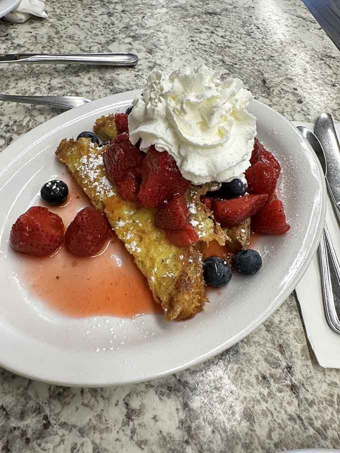 French toast buried under fresh berries and whipped cream proves that dessert for breakfast is always acceptable.