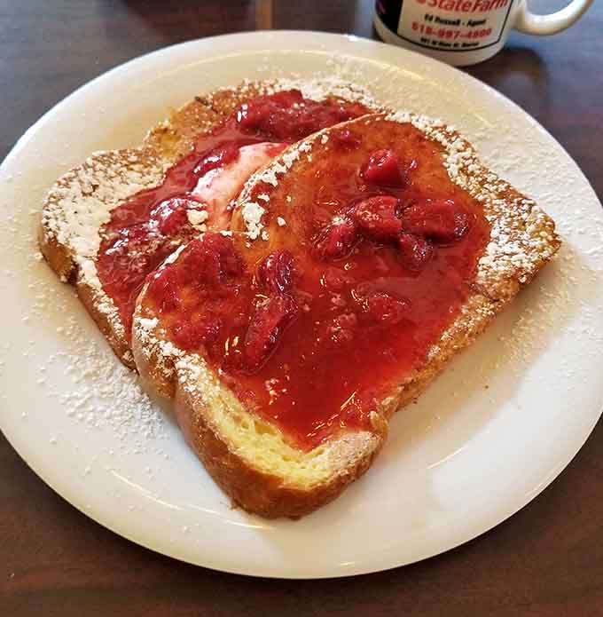 French toast dusted with powdered sugar and crowned with strawberries, because sometimes breakfast needs to dress up fancy.