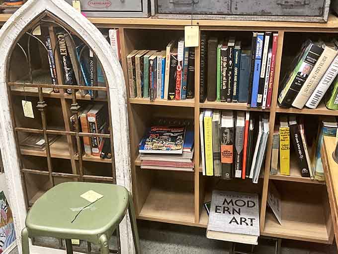 Books and curiosities arranged like a literary flea market, complete with that charming "Modern Art" sign pointing the way.