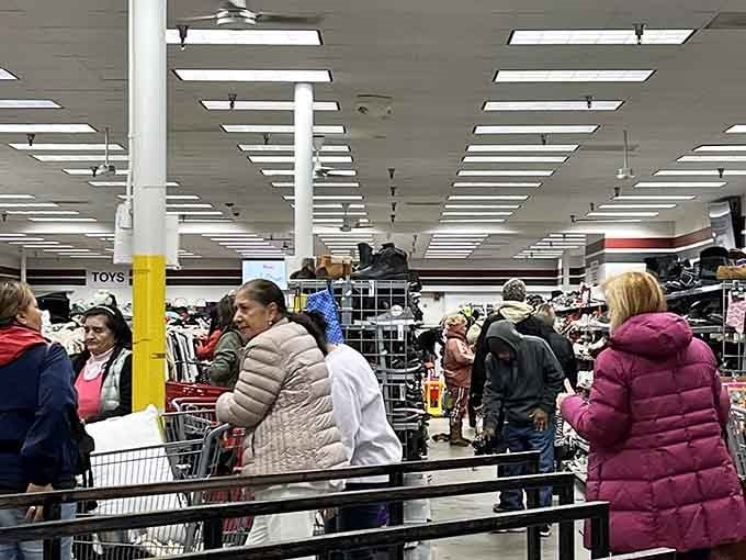 Fellow treasure hunters navigate the aisles with carts full of discoveries and dreams of bargains.