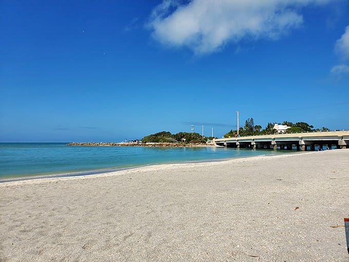 That perfect curve of white sand meets impossibly clear water where shell collectors find treasures like kids on Easter.