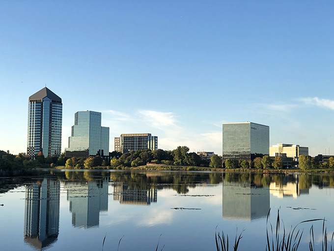 Glass towers reflect perfectly in still water, creating a mirror image that would make Narcissus feel right at home.