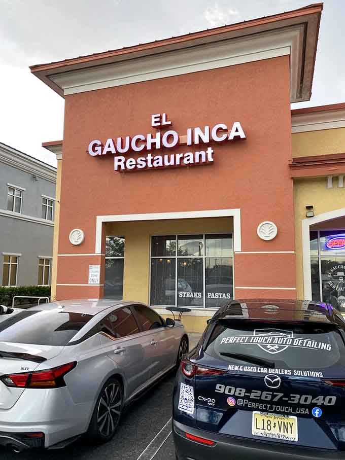 That coral-colored facade and bold lettering signal authentic South American flavors waiting inside this strip mall treasure.