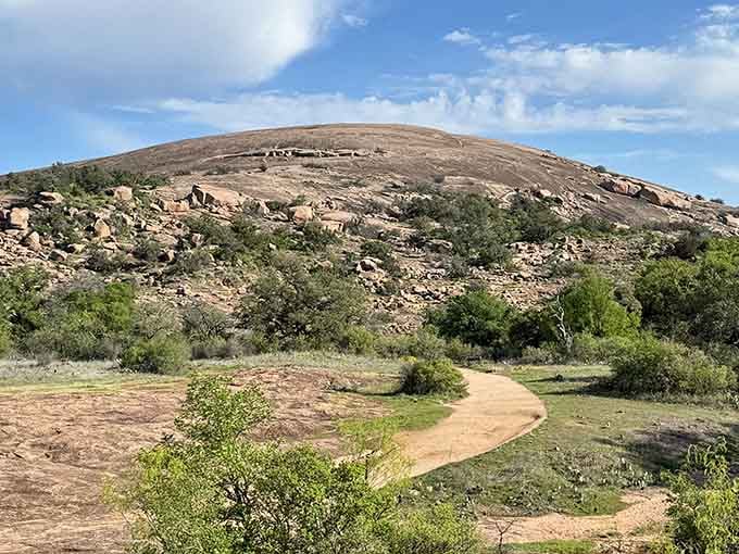 That winding path invites you toward a billion-year-old pink granite dome rising majestically from Hill Country below.
