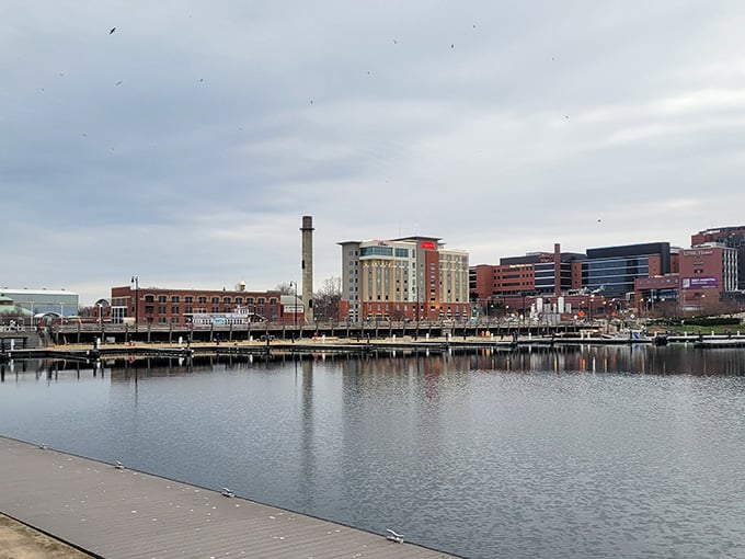 The waterfront reflects modern buildings and old smokestacks, showing how industrial towns reinvent themselves while honoring their past beautifully.