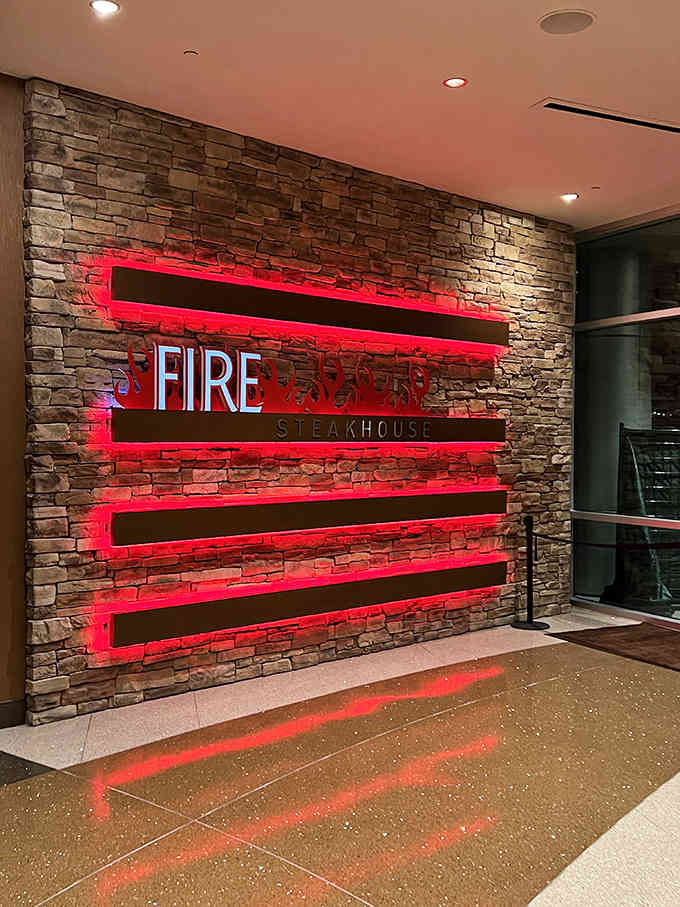 Bold red neon against exposed brick creates drama that matches the sizzle of perfectly grilled steaks inside.