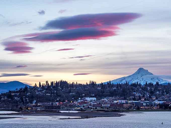 Purple-streaked clouds swirl above Mount Hood in a sunset display that looks almost too beautiful to be real.