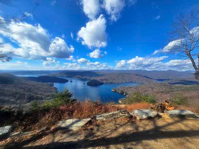 Lake Jocassee spreads below like a giant mirror reflecting puffy clouds sailing across the Carolina sky.