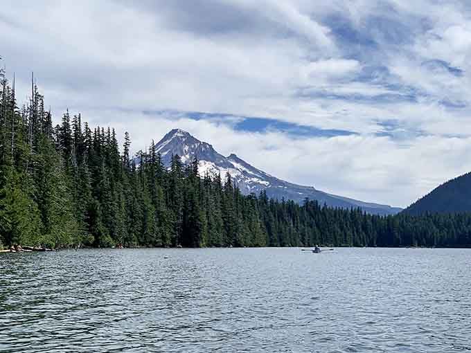 Mount Hood's perfect snow-capped peak reflects in still waters while a lone kayaker enjoys the million-dollar view.