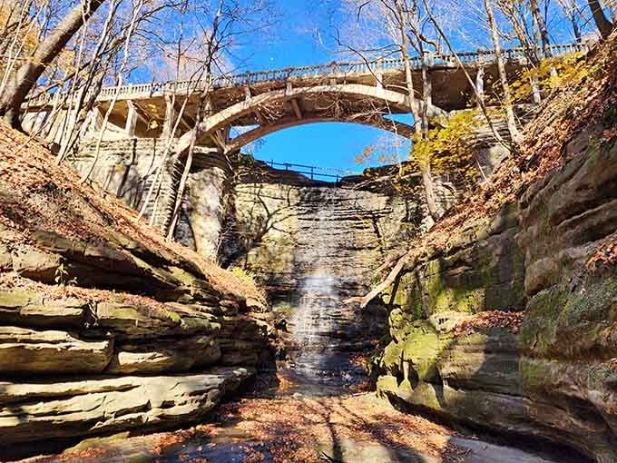 A bridge stretches high above the canyon, while layered rock walls tell stories written in sediment over countless centuries.