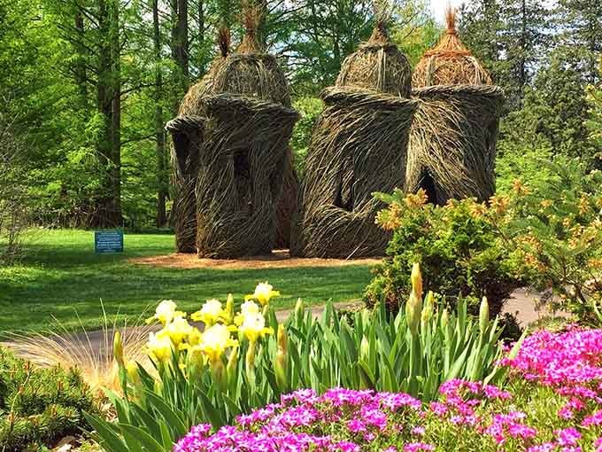 Woven sculptures rising among spring blooms blend human creativity with nature's colorful canvas perfectly here.