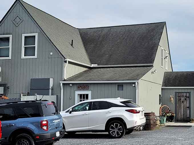 The farmhouse-style building tucked among modern vehicles proves the best dining experiences often hide in plain sight.