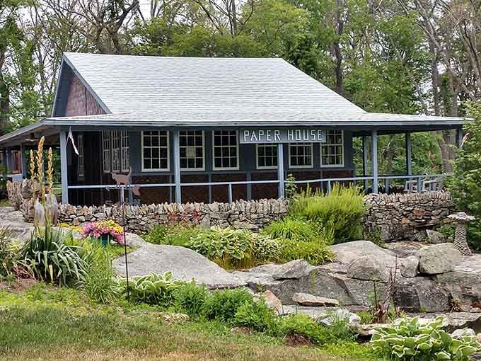 The dark Paper House exterior nestled among rocks and gardens looks deceptively ordinary until you learn its unusual construction.