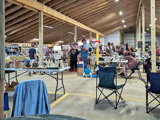 Exposed wooden beams soar overhead in this spacious pavilion where vendors display their carefully curated collections on white-draped tables.