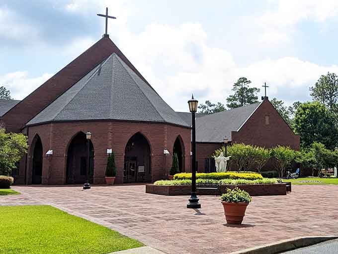 Brick archways frame a peaceful courtyard where manicured gardens invite quiet contemplation and leisurely afternoon walks under Southern sun.