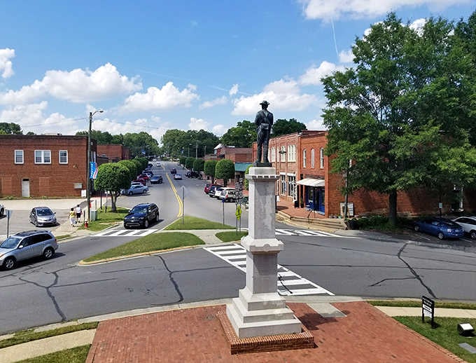 The statue stands guard where the streets meet, a bronze reminder of stories that shaped this town.