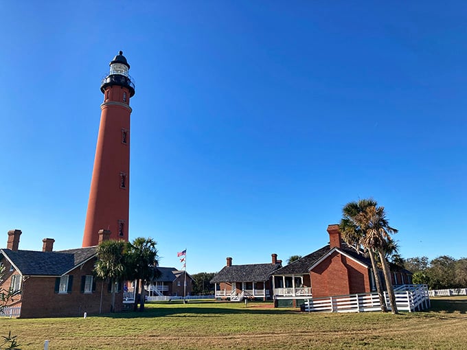 That distinctive red brick color makes this tall tower impossible to miss, standing proud like a terracotta giant among the palms.