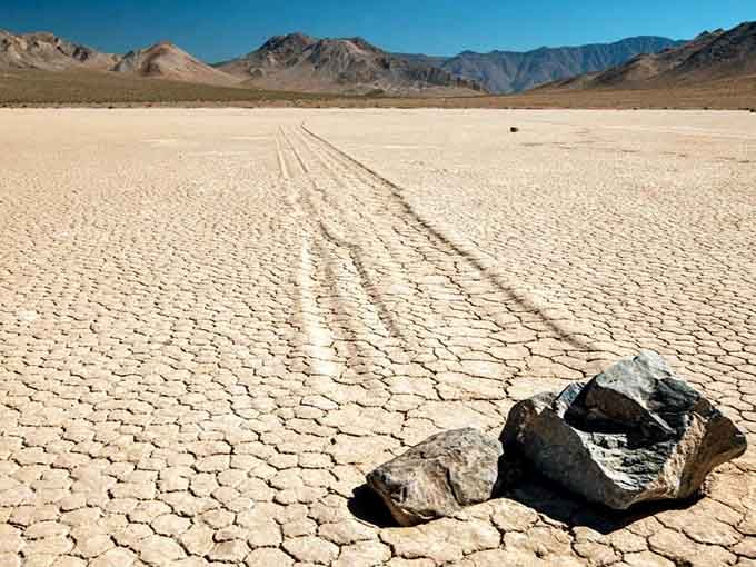 A lone rock sits at the end of its mysterious trail, evidence of nature's slowest magic trick performed across the playa.