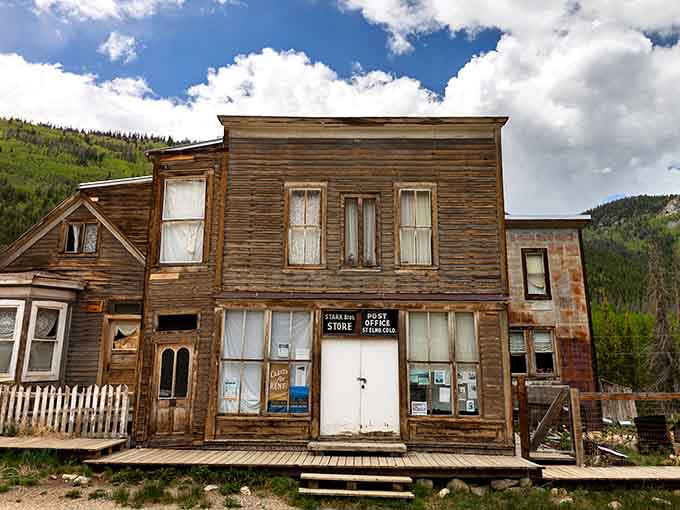 The weathered two-story storefront stands tall, its wooden facade silvered by decades of mountain sun and snow.