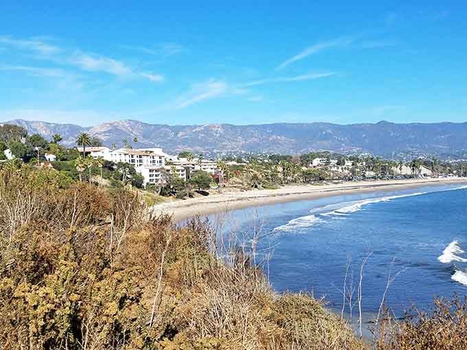 Mountains embrace this coastal paradise where white buildings cascade toward blue water in classic Mediterranean fashion, California-style.