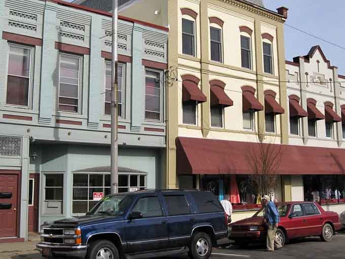 Victorian storefronts wear their age gracefully, with burgundy awnings adding pops of color to cream and mint facades.