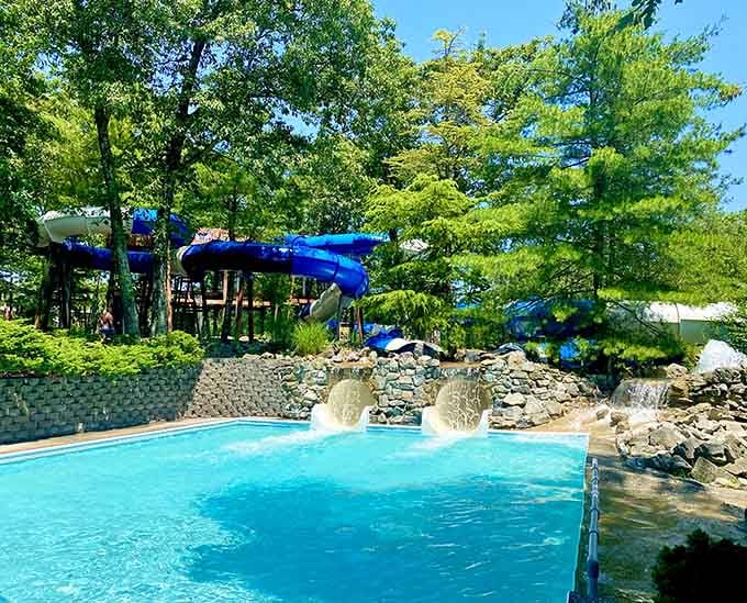 Those twin fountains shoot up like synchronized swimmers celebrating, while blue slides tower overhead waiting for brave souls.