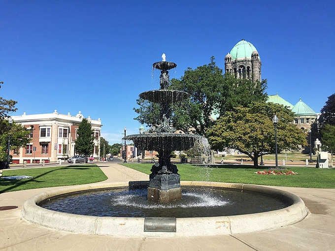 The ornate fountain sparkles in the sunshine, creating a peaceful gathering spot beneath that magnificent copper dome.