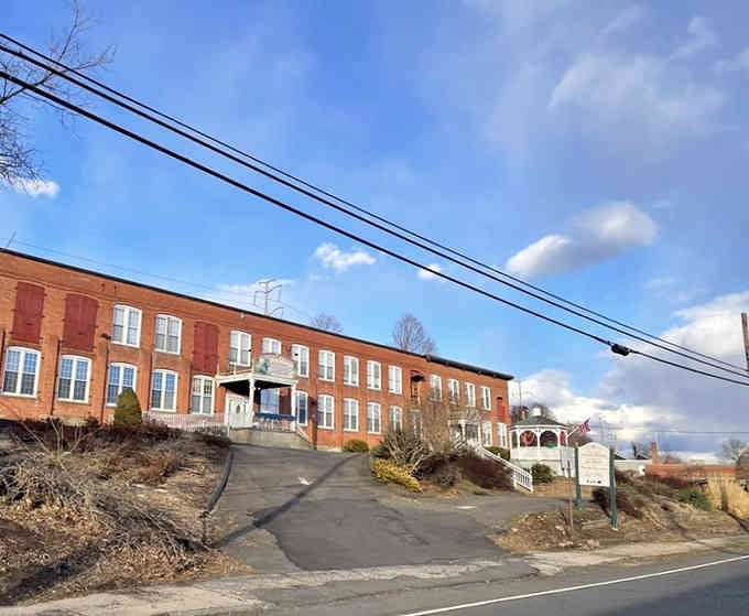 This stately brick facade conceals a carousel wonderland where childhood dreams spin eternal in polished wooden glory.