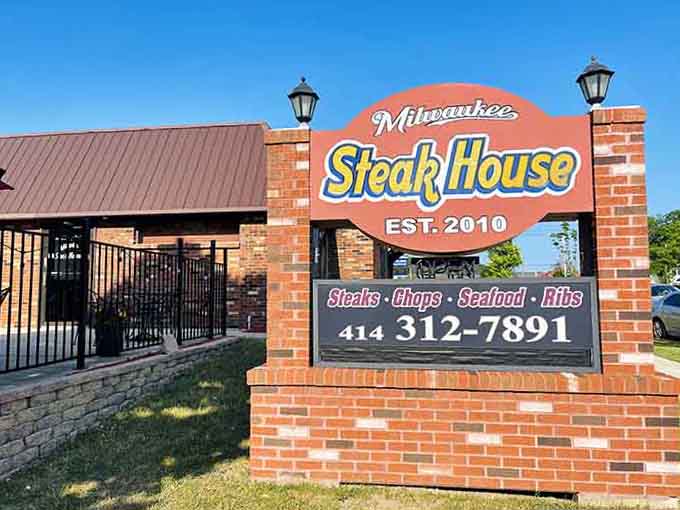 The cheerful orange sign practically shouts "great steaks here!" and the brick pillars add neighborhood-friendly charm all around.