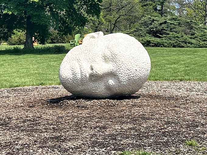 A smooth white stone rests like a giant's forgotten treasure, its dimpled surface catching light and shadow beautifully.