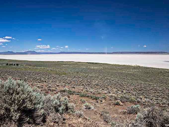 Sagebrush dots the foreground while the white expanse beyond shimmers like something from a Salvador Dali painting come alive.