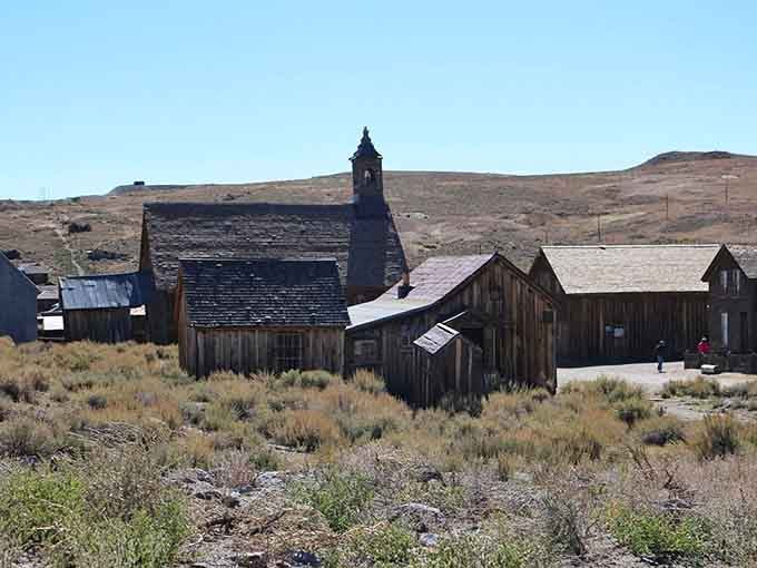 The church steeple rises above weathered structures in this high-desert ghost town, where sagebrush now outnumbers the former congregation.