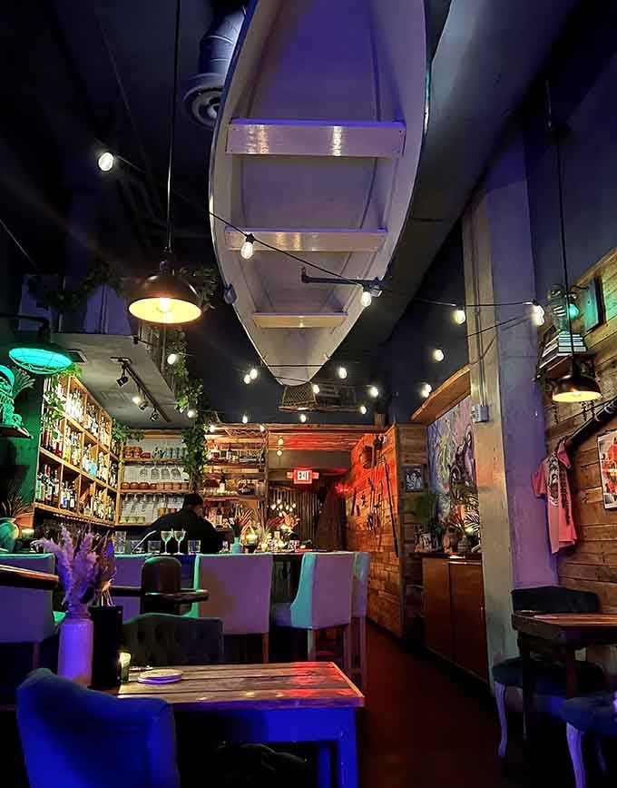 A suspended boat overhead and moody lighting create the perfect atmosphere for seafood lovers seeking maritime magic.