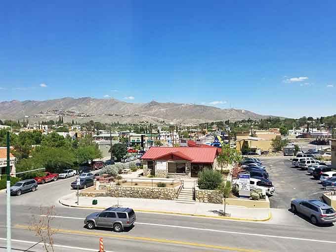 Mountains frame this desert city like a natural postcard, where red-roofed buildings dot the landscape beneath peaks that touch the clouds.