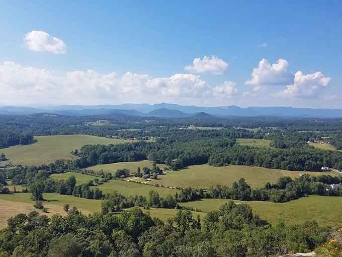 Puffy clouds drift over this pastoral valley where green fields meet forested hills in perfect harmony and peace.