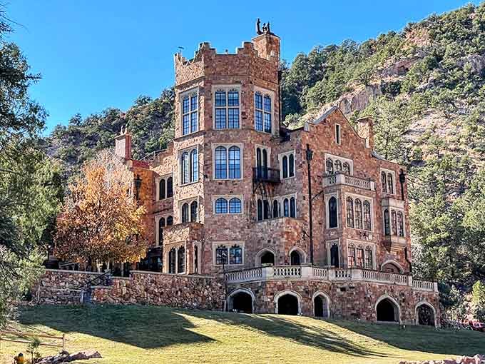 Afternoon shadows stretch across manicured lawns surrounding this red sandstone castle that looks straight out of a storybook.