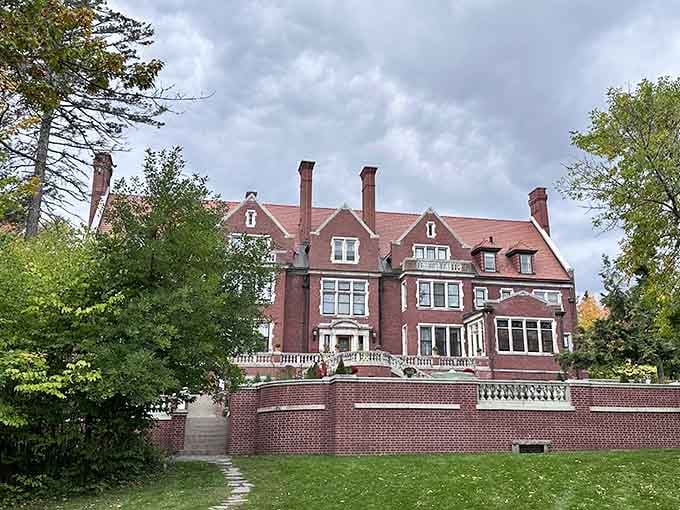 Mature trees frame the mansion's profile, softening its grandeur while emphasizing the estate's privileged position above Superior's shores.