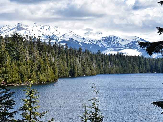 Forest-lined shores frame the mountain's majestic silhouette like nature composed this scene just for your camera roll.