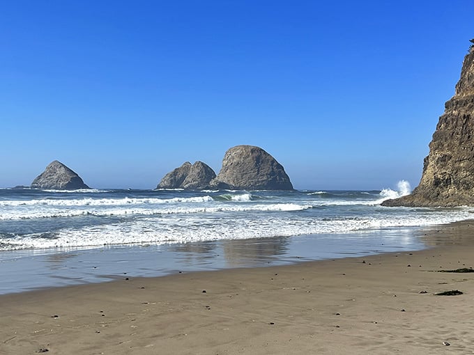 The rugged coastline stretches ahead, with offshore rocks standing tall against the rolling waves.