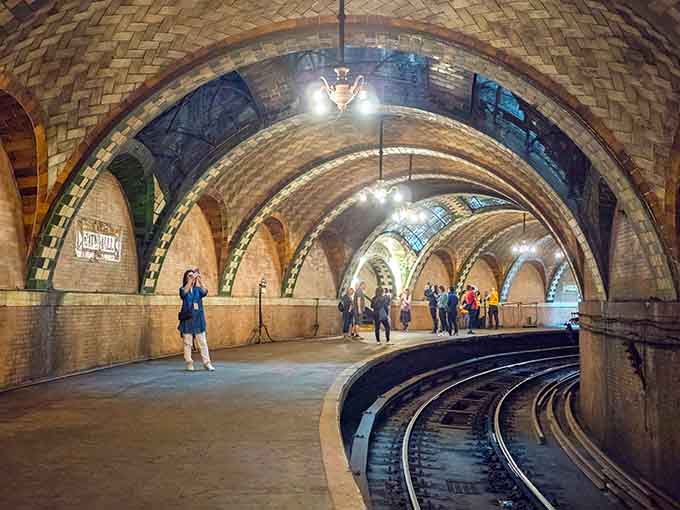 Visitors gather beneath glowing skylights and brass chandeliers in this hidden architectural treasure beneath Manhattan's streets.