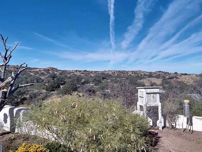 That weather station stands sentinel over high desert terrain where clouds drift lazily across an endless blue canvas.