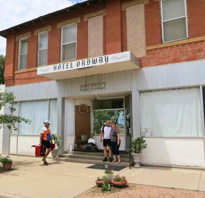 The Hotel Ordway's weathered sign welcomes cyclists like a beacon from another era, potted plants softening the entrance.