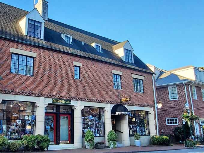 Classic New England-style brick buildings house charming shops, their green awnings adding a splash of color to timeless architecture.