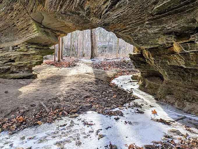 Winter's touch transforms the arch into a frosted wonderland where ice and stone create temporary masterpieces together.
