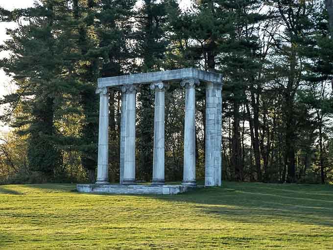 These classical columns stand as a solemn memorial where soldiers fought bravely, their courage echoing through the quiet trees.