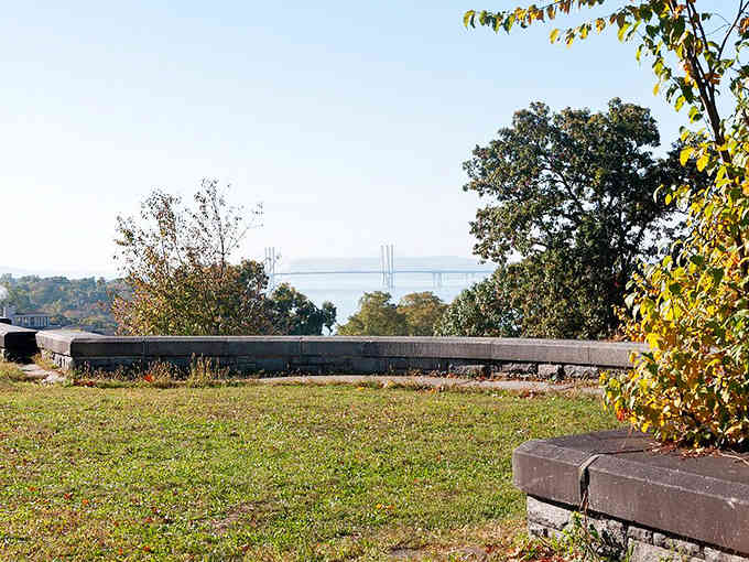 The bridge's distant silhouette frames this peaceful meadow, where history and nature have learned to share the space.