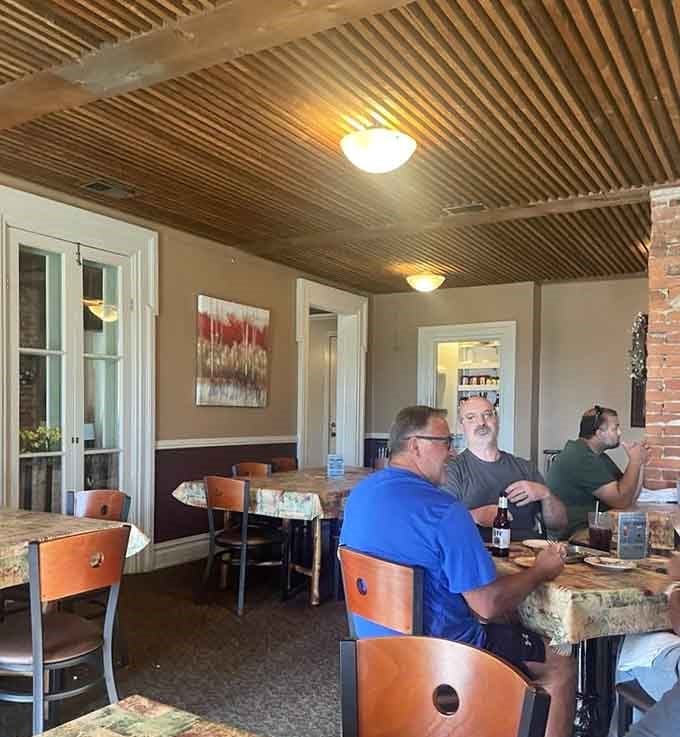 The corrugated metal ceiling adds rustic charm while diners enjoy conversations over meals that bring people together perfectly.