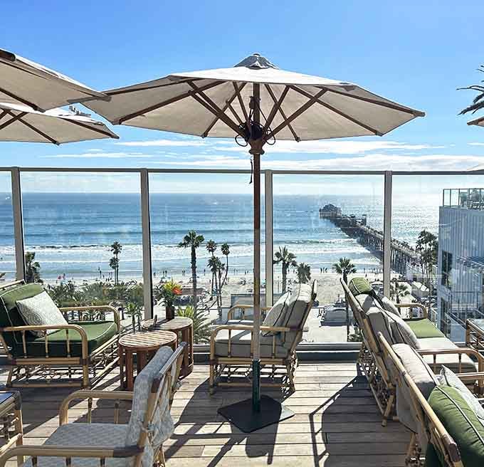 Umbrellas provide shade while the iconic pier stretches into sparkling water just beyond your cocktail.