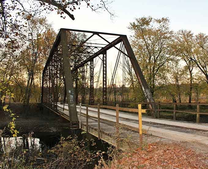 Graffiti marks the concrete abutment, modern signatures on ancient stone, proving every generation leaves its mark somehow.