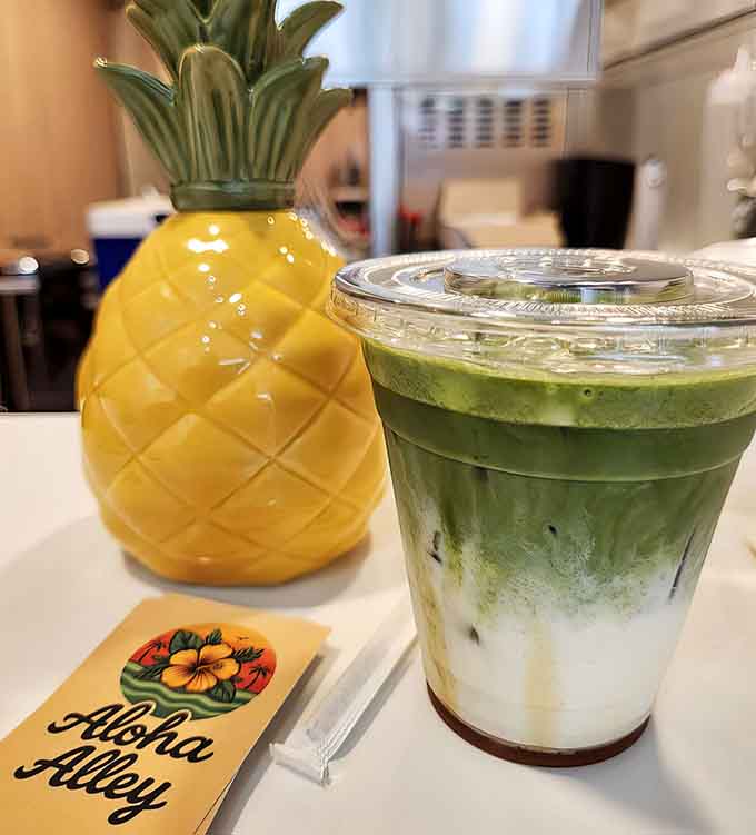 An iced matcha latte served next to a pineapple cup, because even your caffeine deserves a tropical vacation.